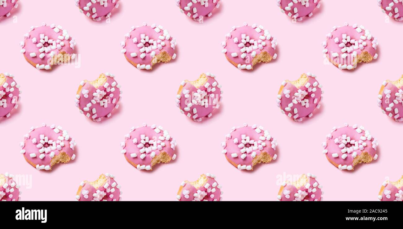 Seamless texture with Bitten icing donut on pink background, isometric ...