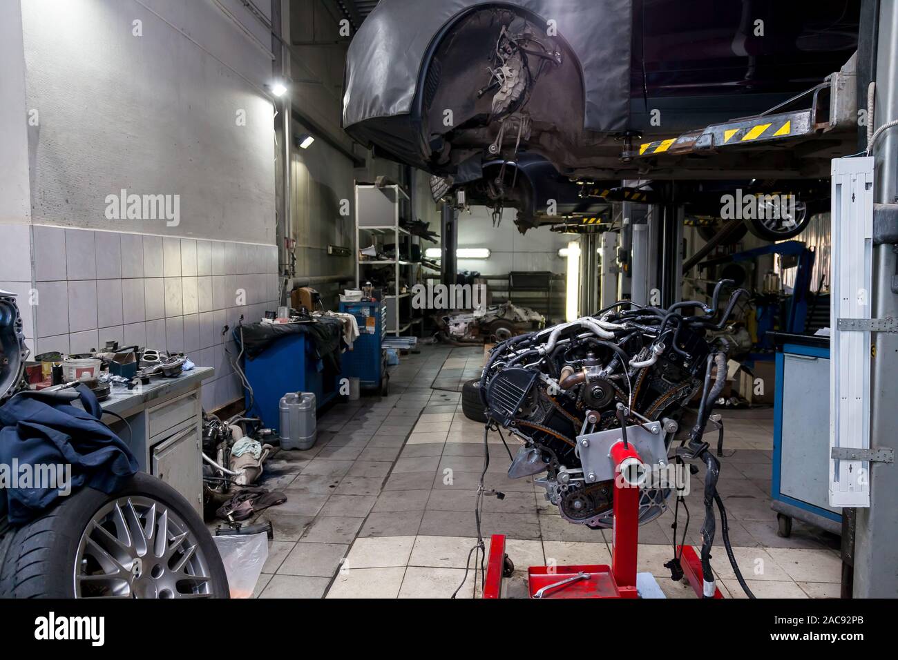 Replacement used engine mounted on a crane for installation on a car ...