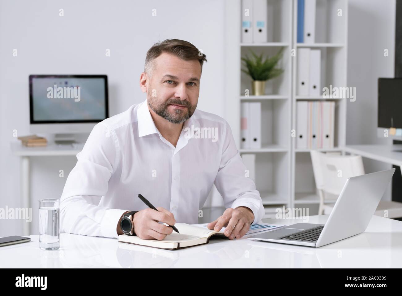 Sitting leadership looking at camera confidence document hi-res stock ...