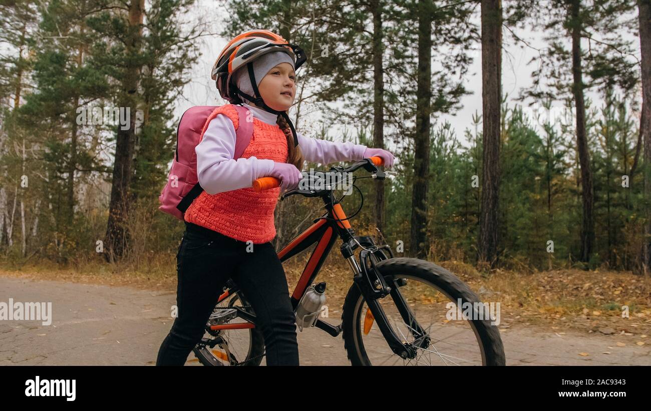 One caucasian children walk with bike in autumn park. Little girl ...