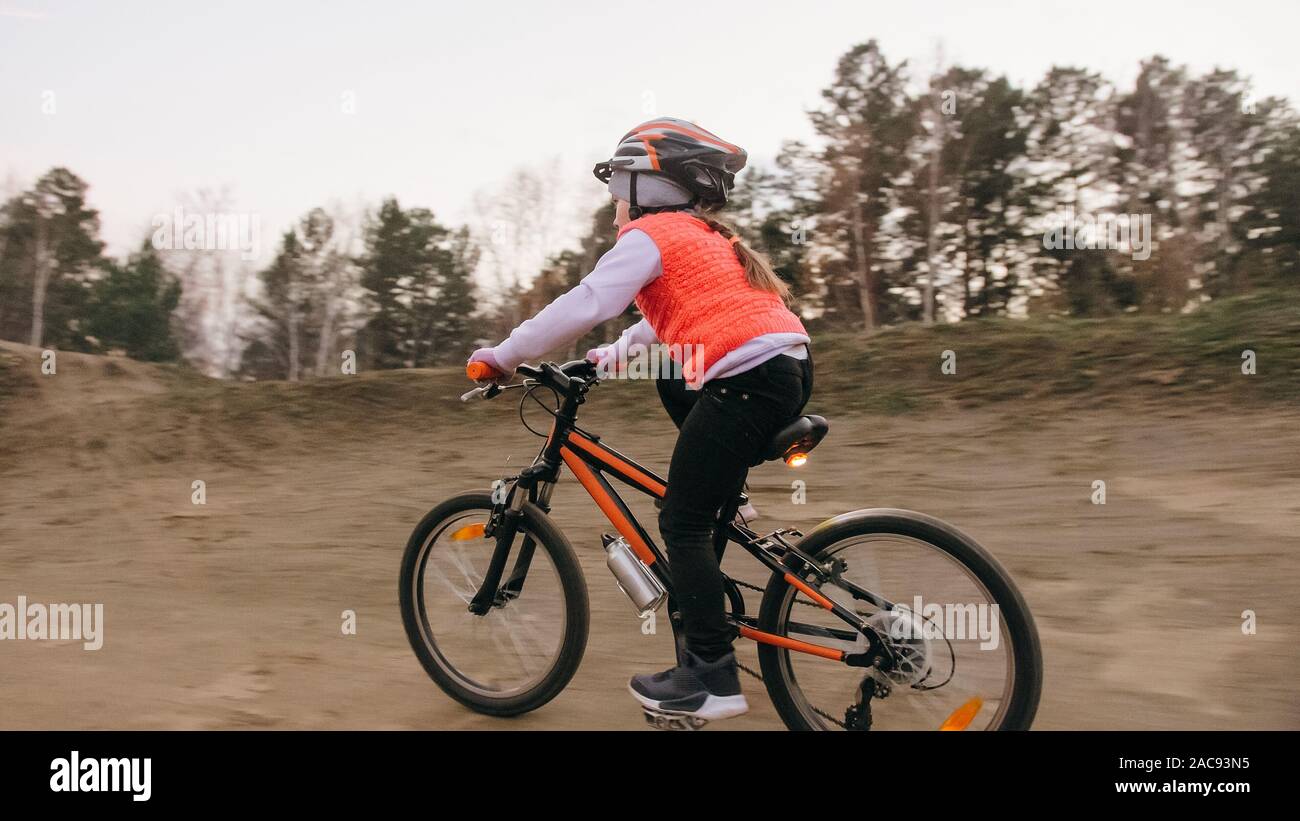 One caucasian children rides bike road track in dirt park. Girl riding ...