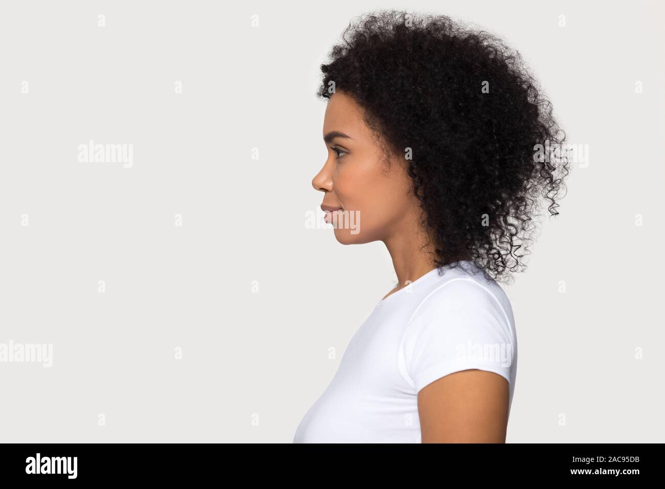 Young attractive African American woman standing in profile, beautiful ...