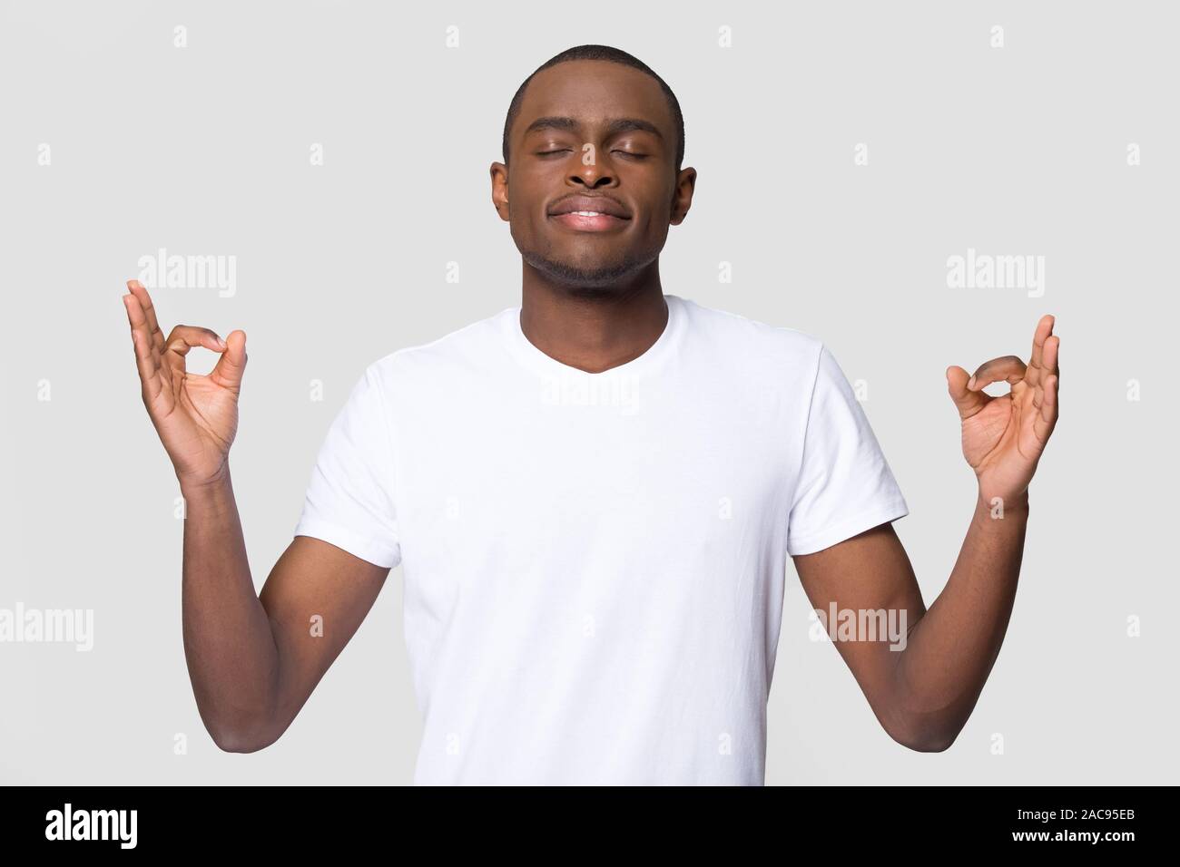 Calm peaceful African American man meditating, mindful young male ...