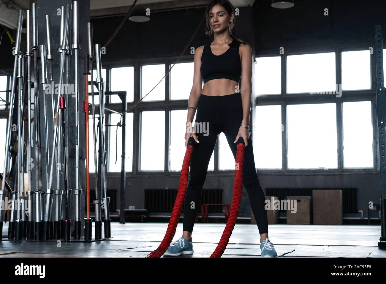 Young woman doing strength training using heavy ropes at the gym Stock ...