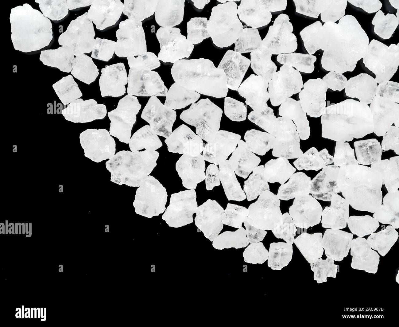 large white crystals of sea salt on black background, close-up, top ...