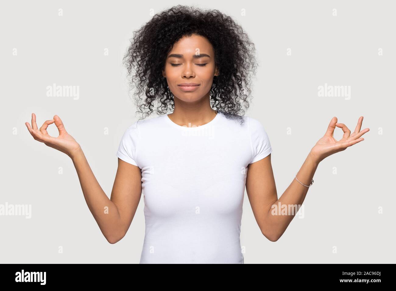 Calm peaceful African American woman meditating with closed eyes Stock ...