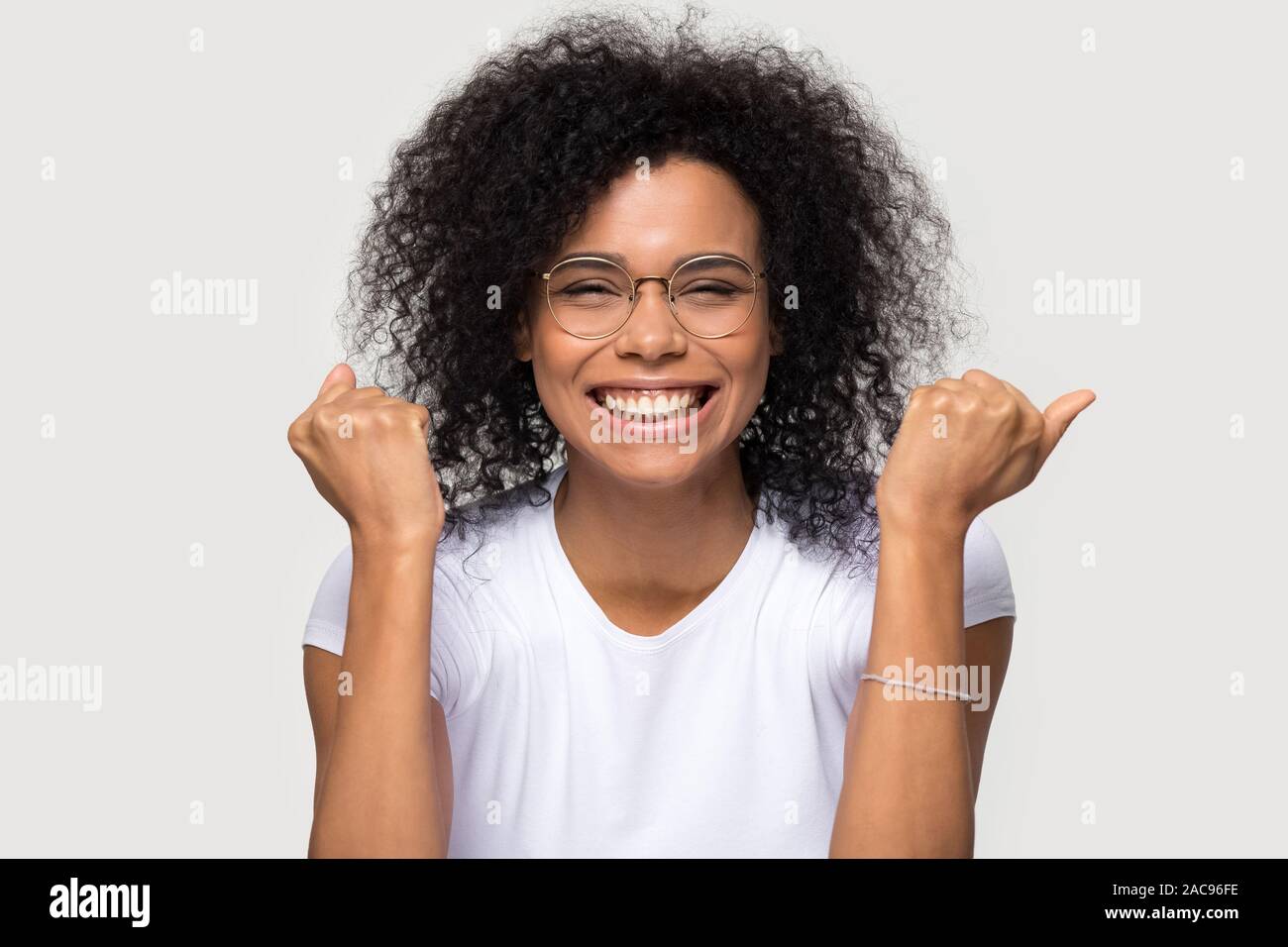 Excited smiling African American woman in glasses celebrating win Stock ...