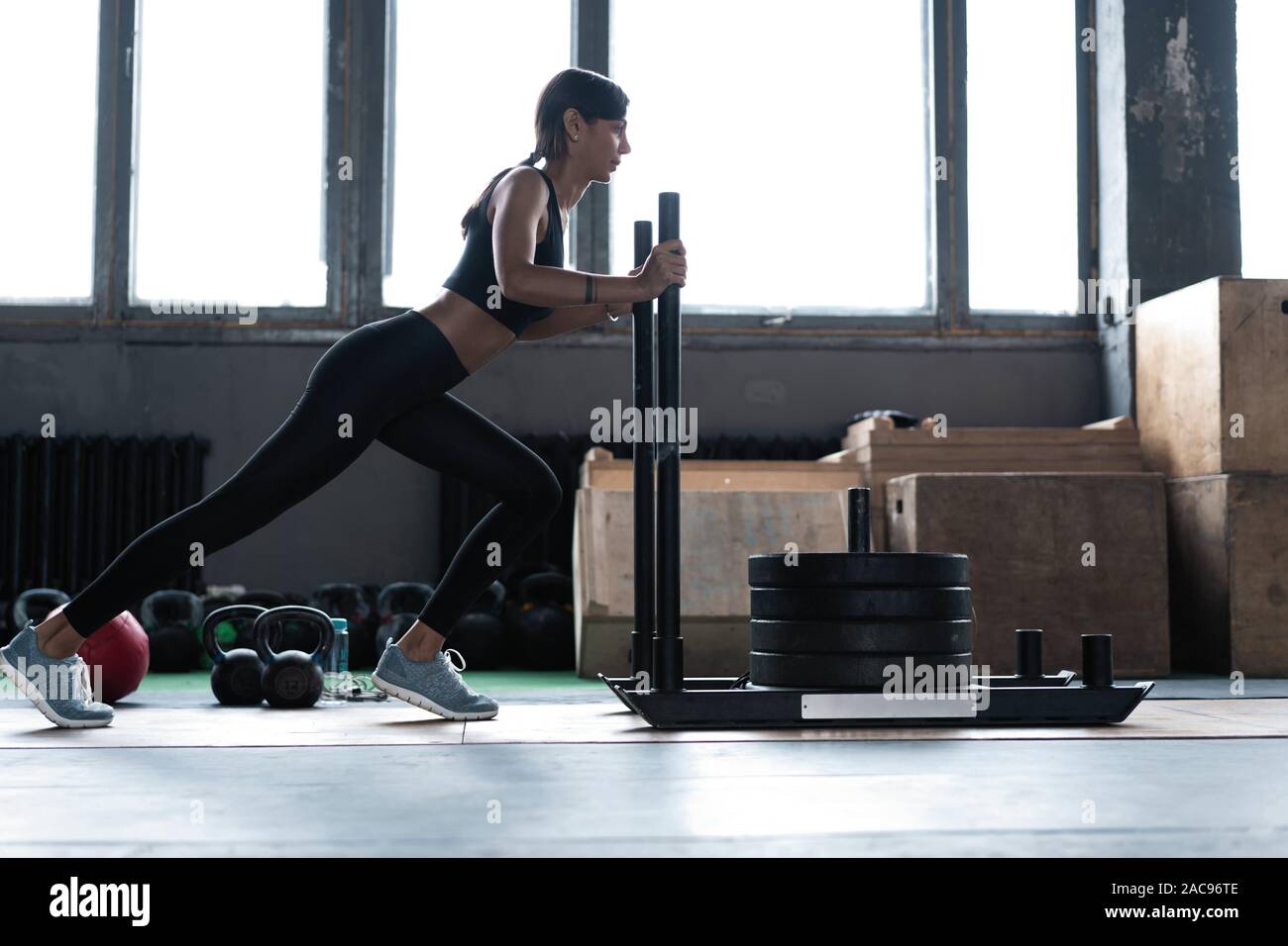 Fit female athlete working out in the gym. Crossfit woman exercising ...