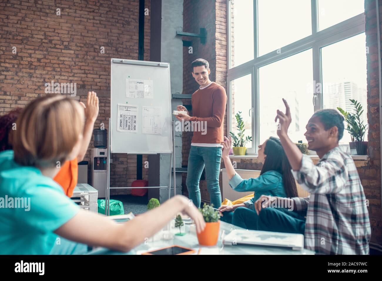 Brainstorming with friends. Curly red-haired student presenting her ...