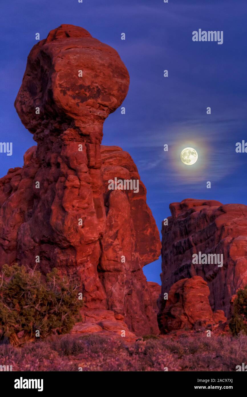 An almost full moon rises over rock formations in the Garden of Eden in ...