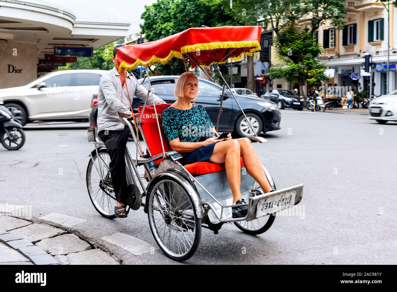 Tourists taking Cyclo Rickshaw ride around Hanoi Vietnam Stock Photo ...