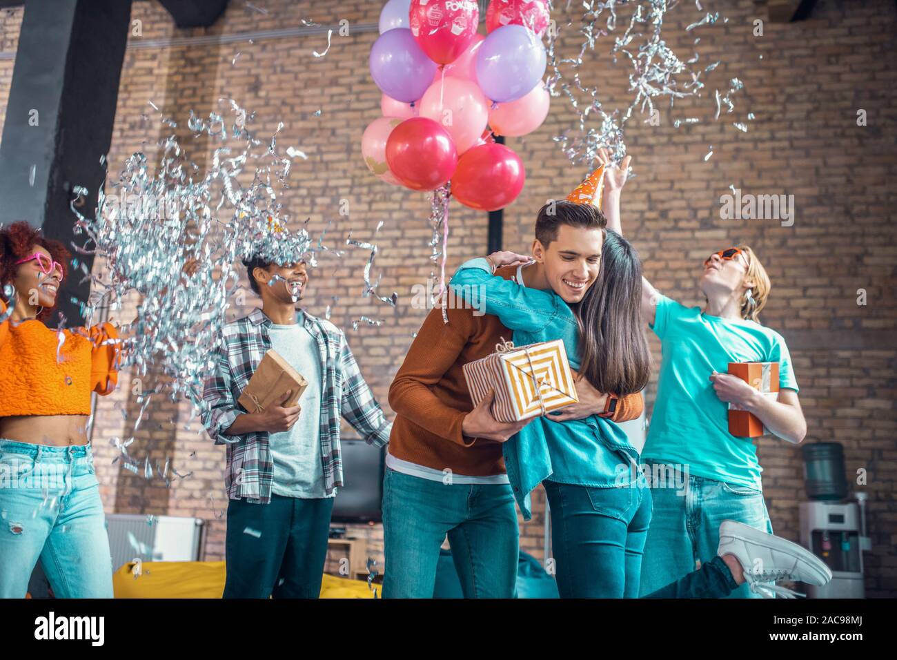 Amazing birthday party. Cheerful good-looking students having amazing ...