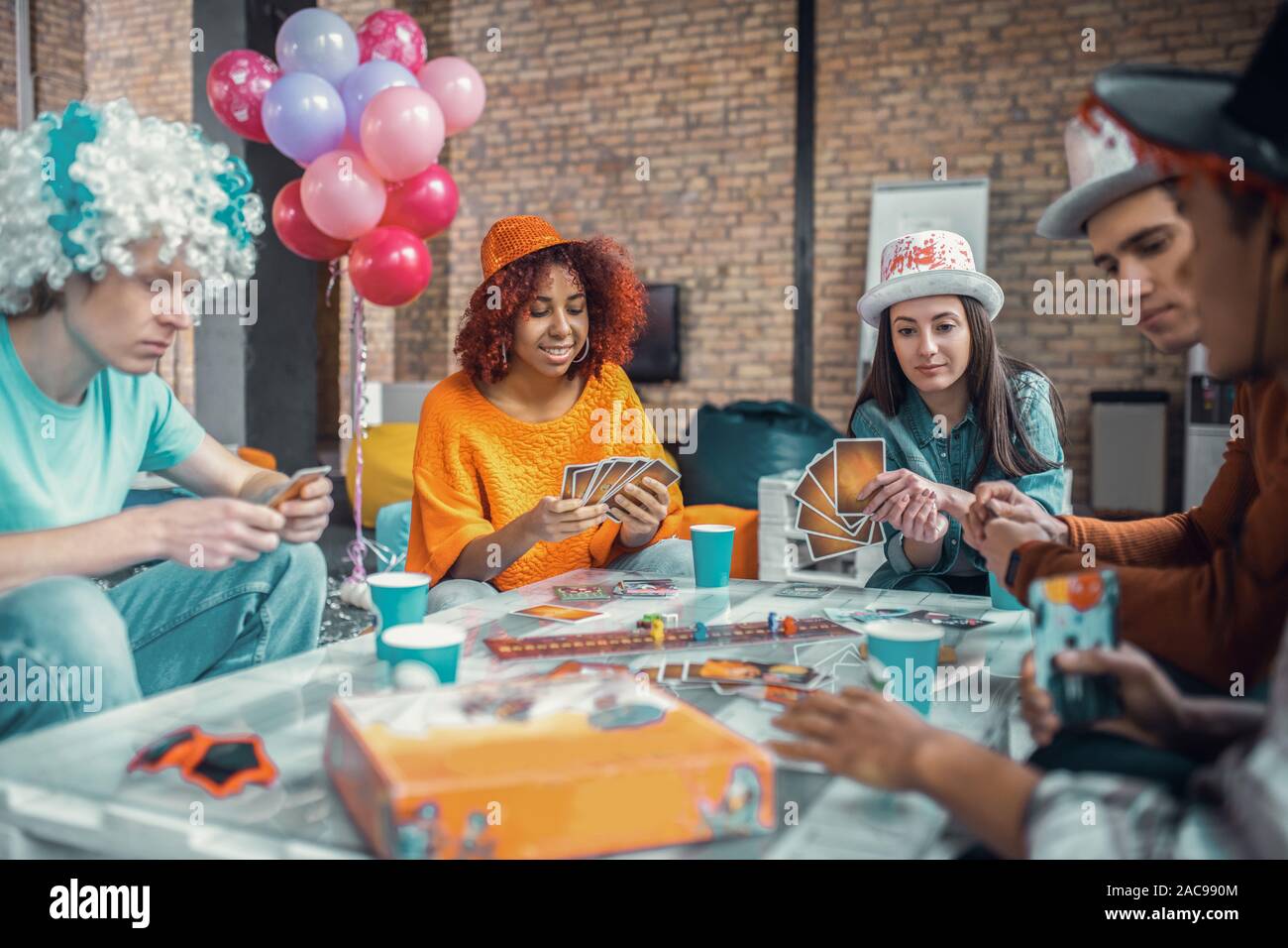 Wearing bright hats. Good-looking students wearing bright hats playing ...