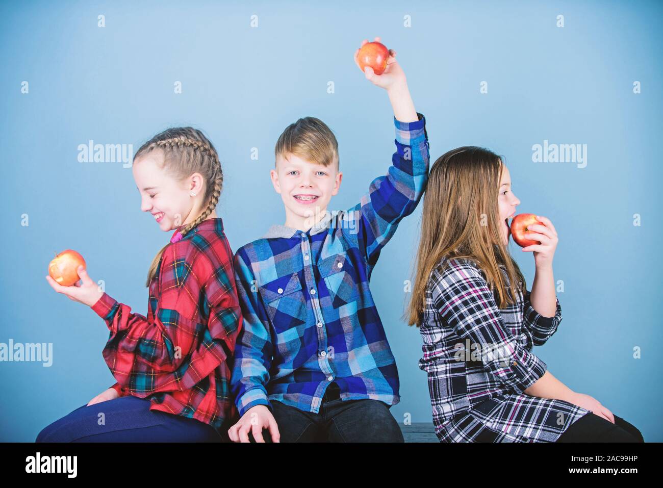 Healthy dieting and vitamin nutrition. Boy and girls friends eat apple ...