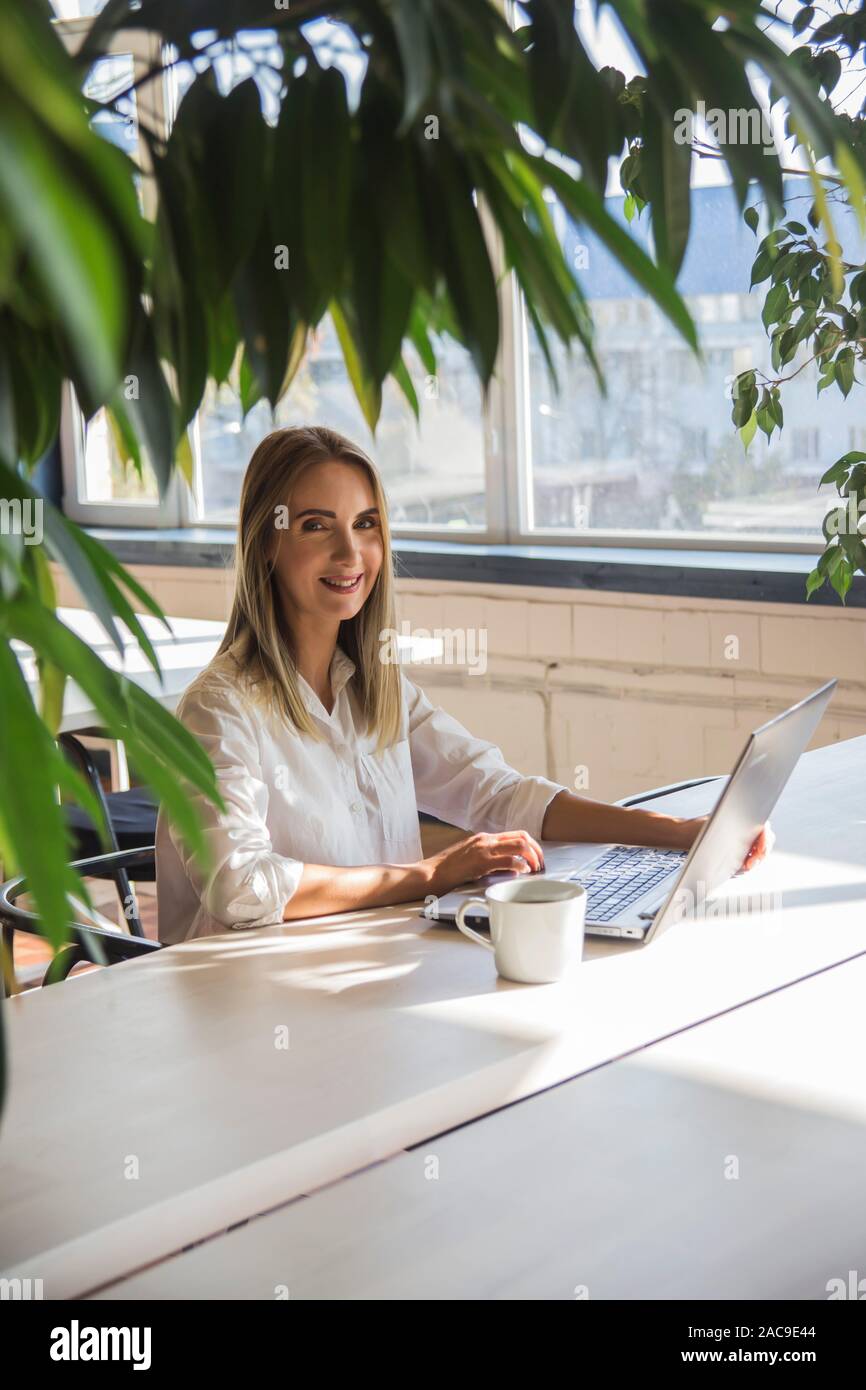 Modern business woman at coffee shop or coworking interior working at a ...
