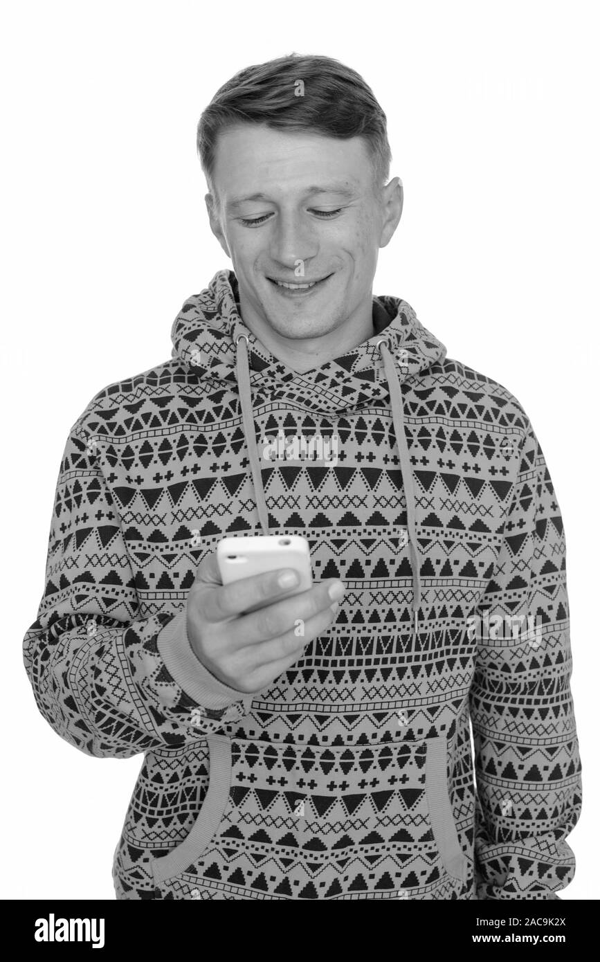 Studio shot of young happy Caucasian man using mobile phone isolated ...