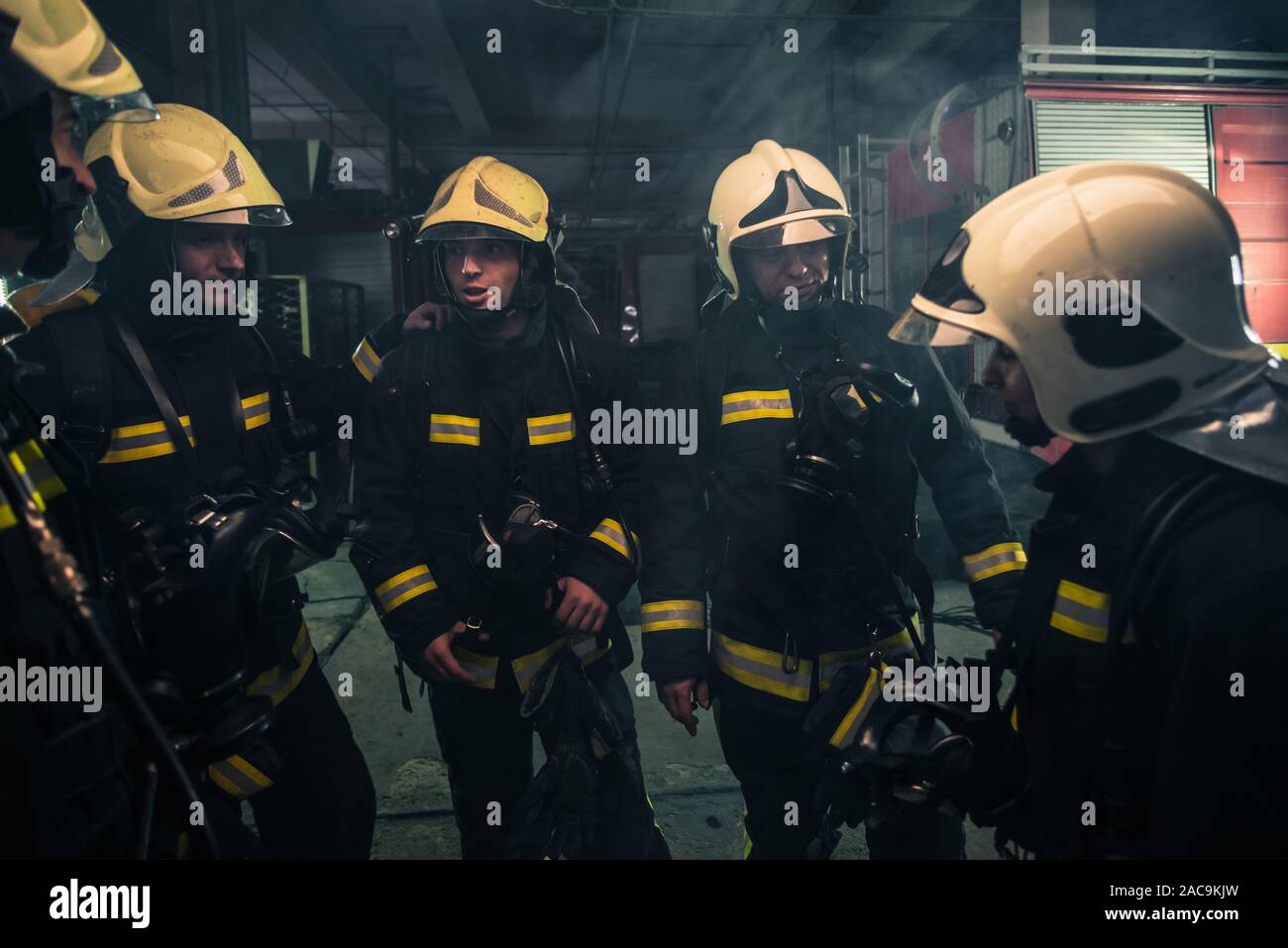 Team of firefighters standing inside ( indoors ) a buliding next to a ...