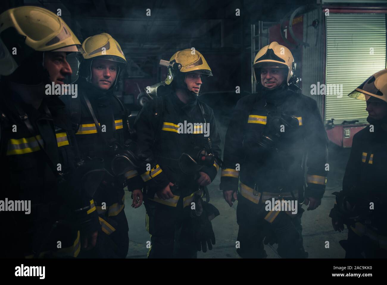 Team of firefighters standing inside ( indoors ) a buliding next to a ...