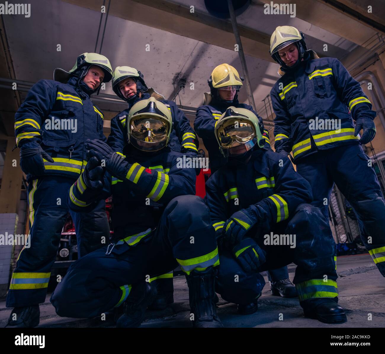 Portrait of group firefighters in front of firetruck inside the fire ...