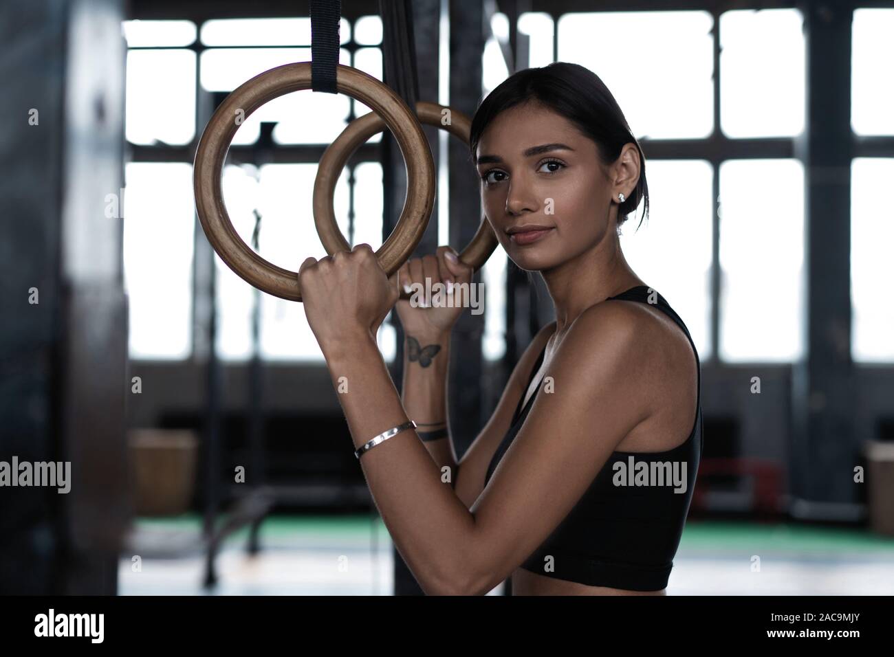 Exercising woman holding gymnast rings. Female taking rest after ...