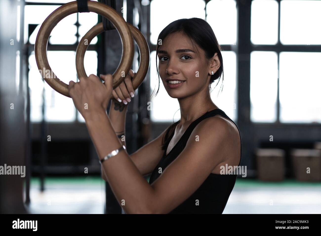 Exercising woman holding gymnast rings. Female taking rest after ...