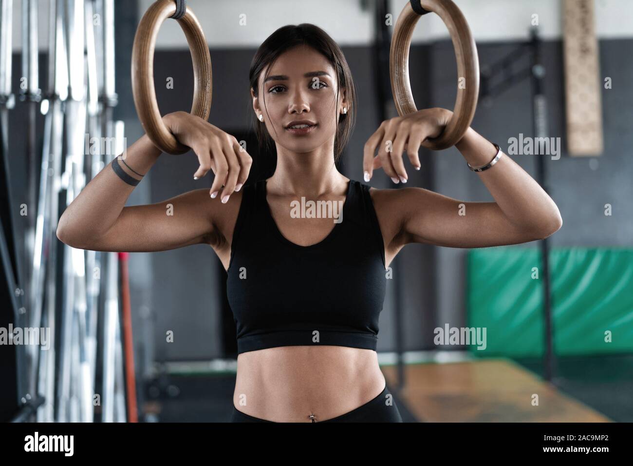 Exercising woman holding gymnast rings. Female taking rest after ...