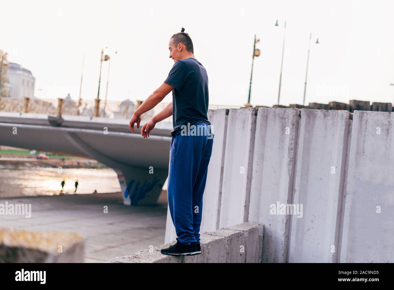 Free runner training parkour jumping on a fence while doing a back flip ...