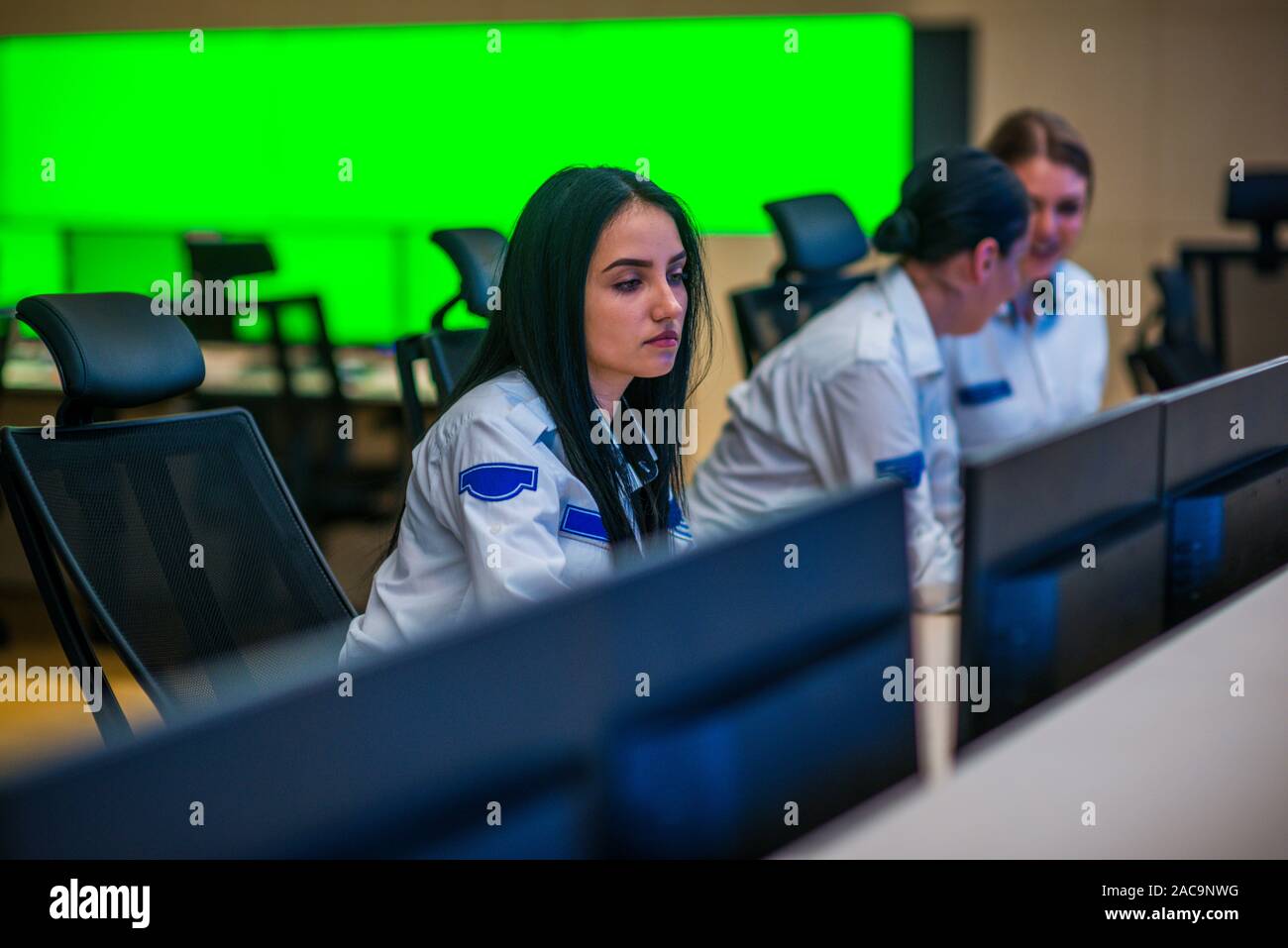 Security guard monitoring modern CCTV cameras in a surveillance room ...