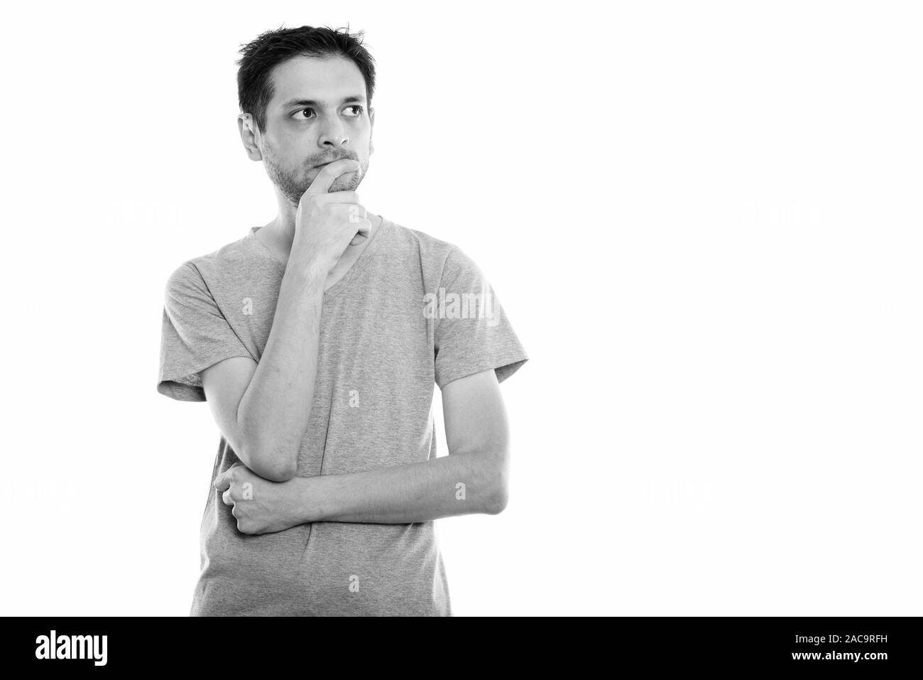 Studio shot of young man thinking while looking up Stock Photo - Alamy
