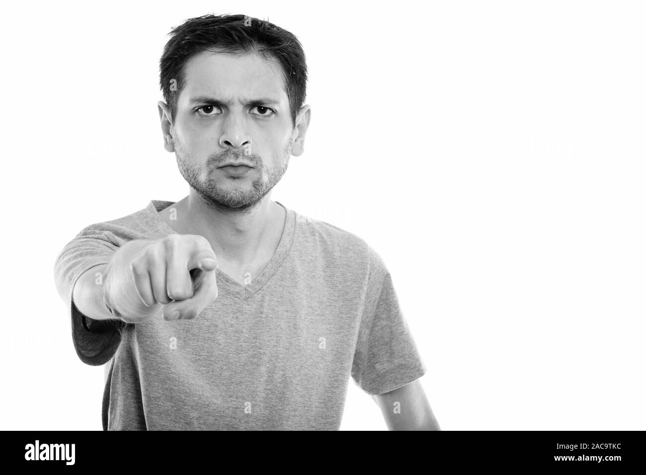 Studio shot of angry young man pointing at camera Stock Photo - Alamy