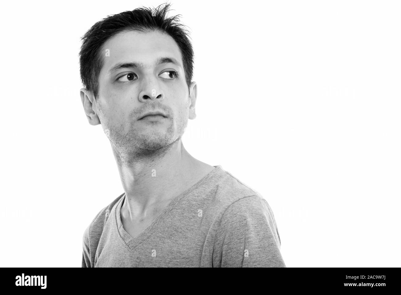Studio shot of young man looking back while thinking Stock Photo - Alamy
