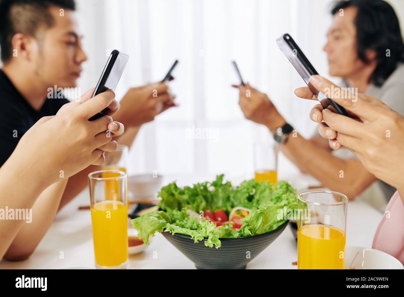 Family members texting and checking social media on smartphones instead ...