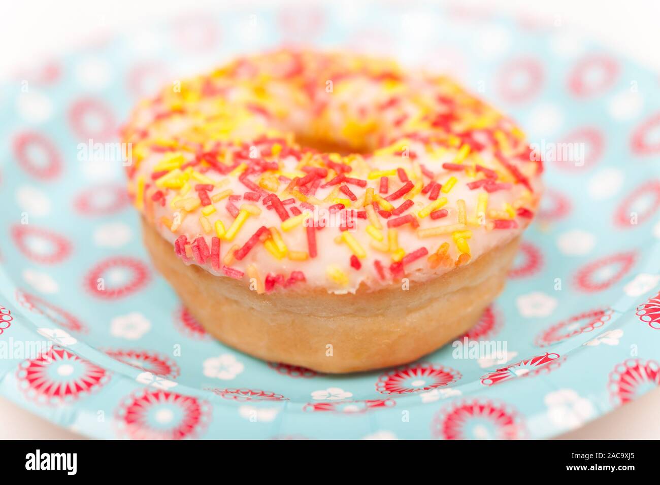 Donut or doughnut with colorful frosting or icing and sprinkles ...
