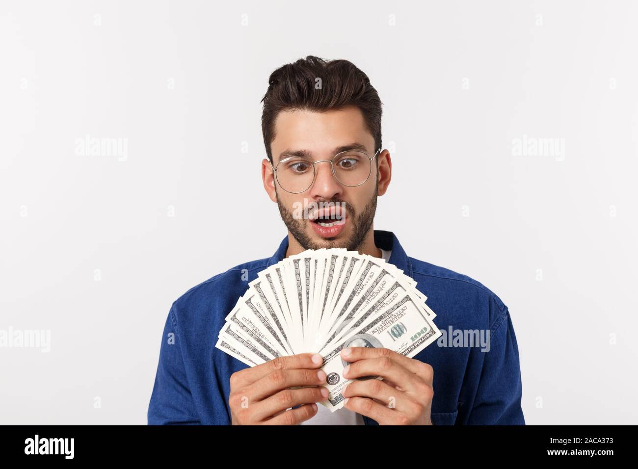 Attractive man is holding cash money in one hand, on isolated white ...