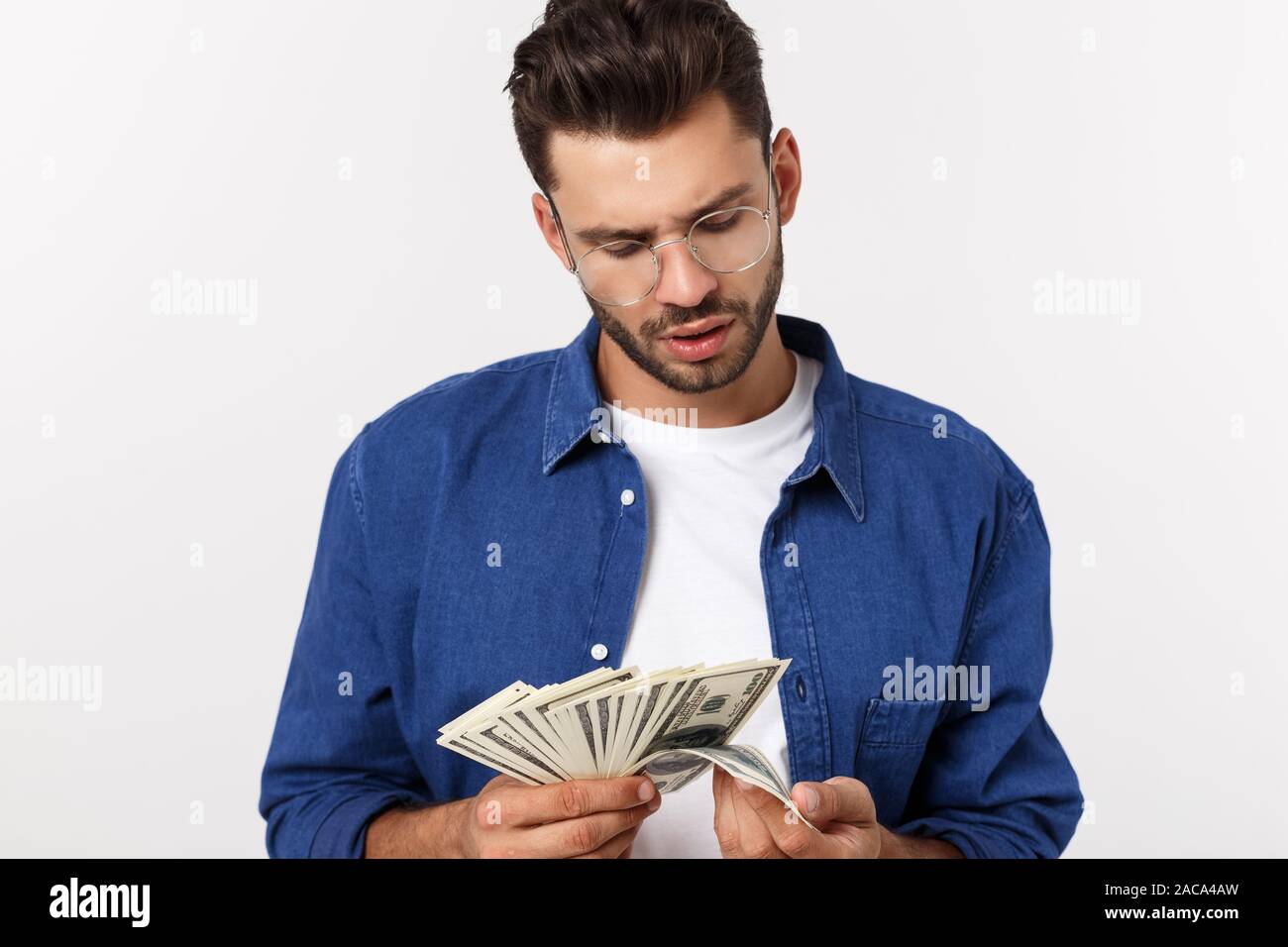 Attractive man is holding cash money in one hand, on isolated white ...
