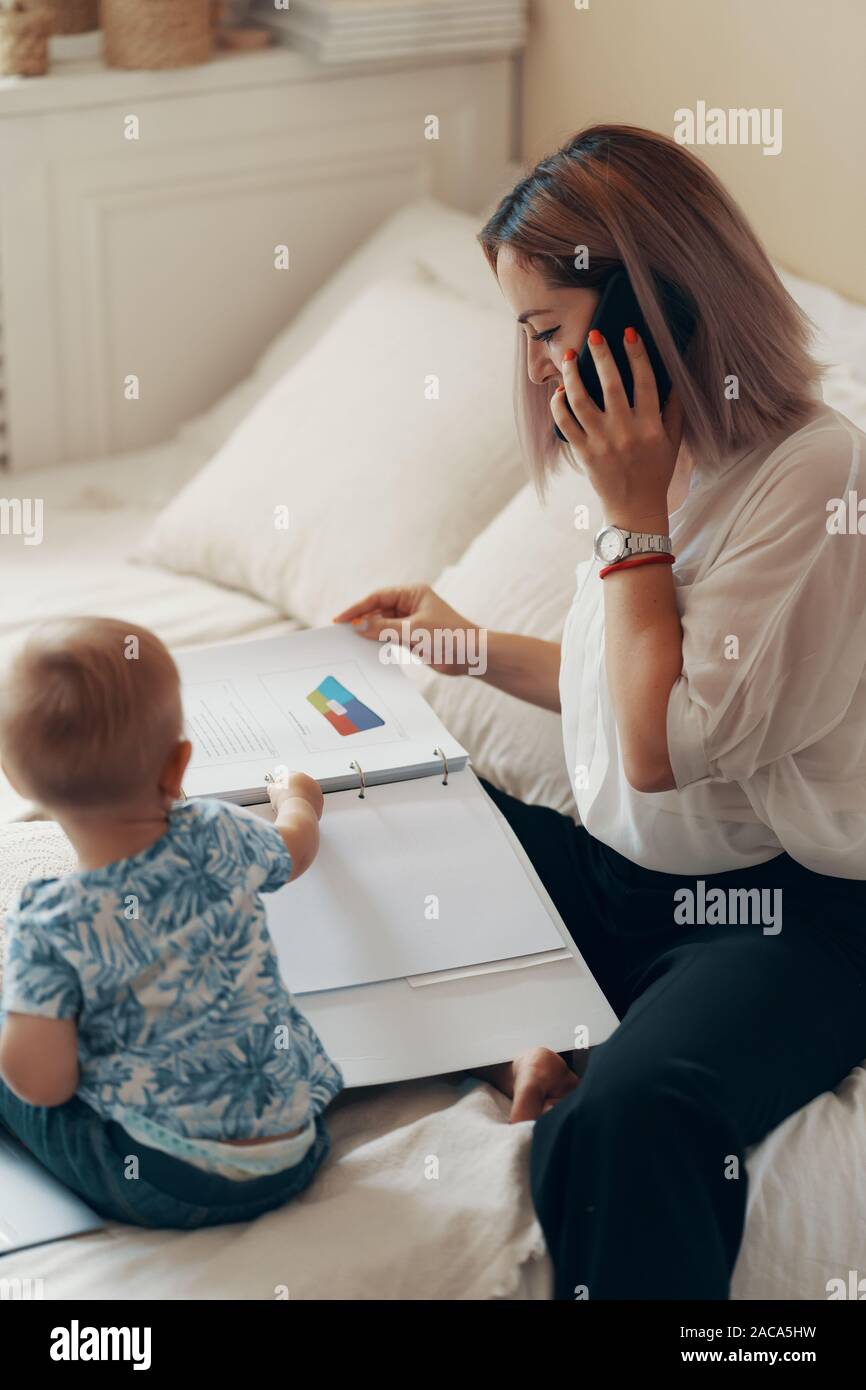 Business mom talking on a cell phone. Multi-tasking, freelance and ...