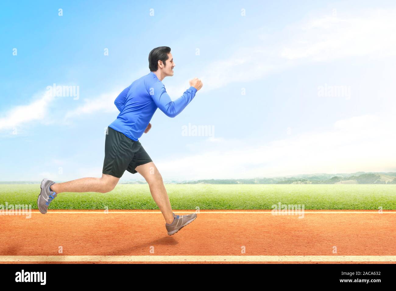 Asian runner man running on the running track with a blue sky ...