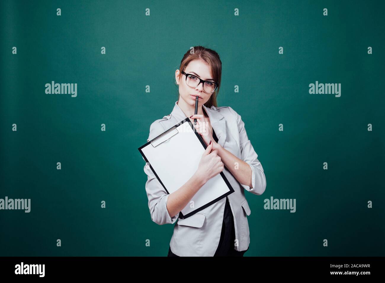 teacher in a business suit stands at green board Stock Photo - Alamy