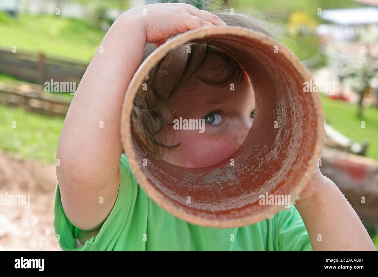 Child looks through pipe Stock Photo - Alamy