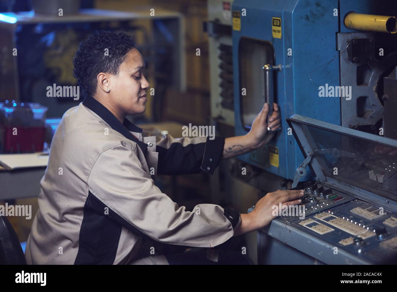 Side view portrait of female worker turning handles while operating ...