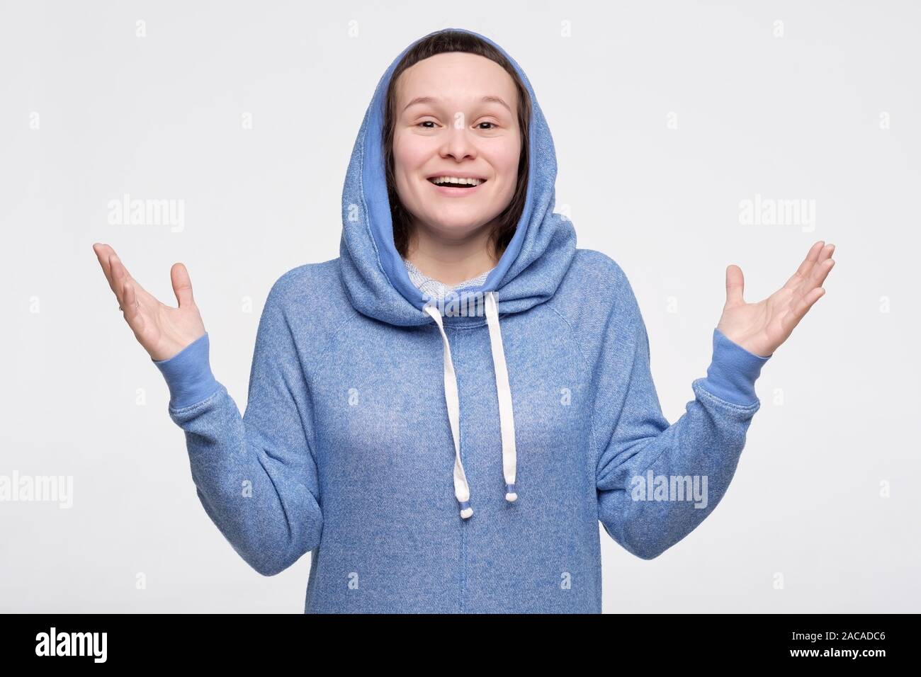 Young caucasian woman in blue clothes being excited raising hands up ...