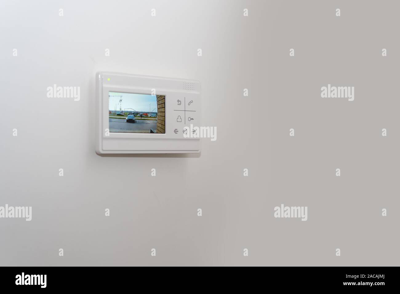 video intercom on a white wall near the entrance door to the apartment ...