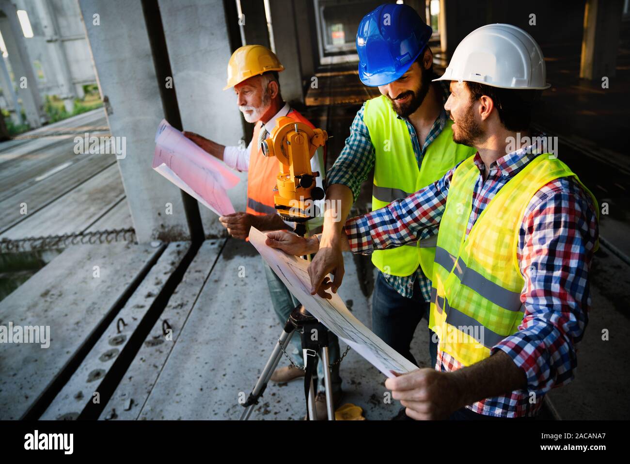 Team of construction engineers, architects working on building site ...