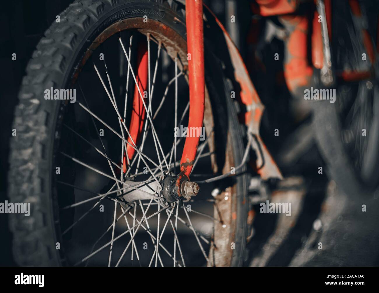 The wheel of a red old rusty Bicycle standing outside in the bright ...
