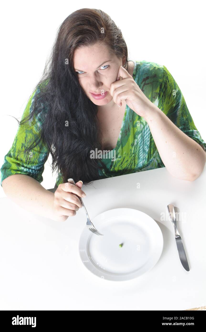 Woman in front of empty plate has diet frustration Stock Photo - Alamy