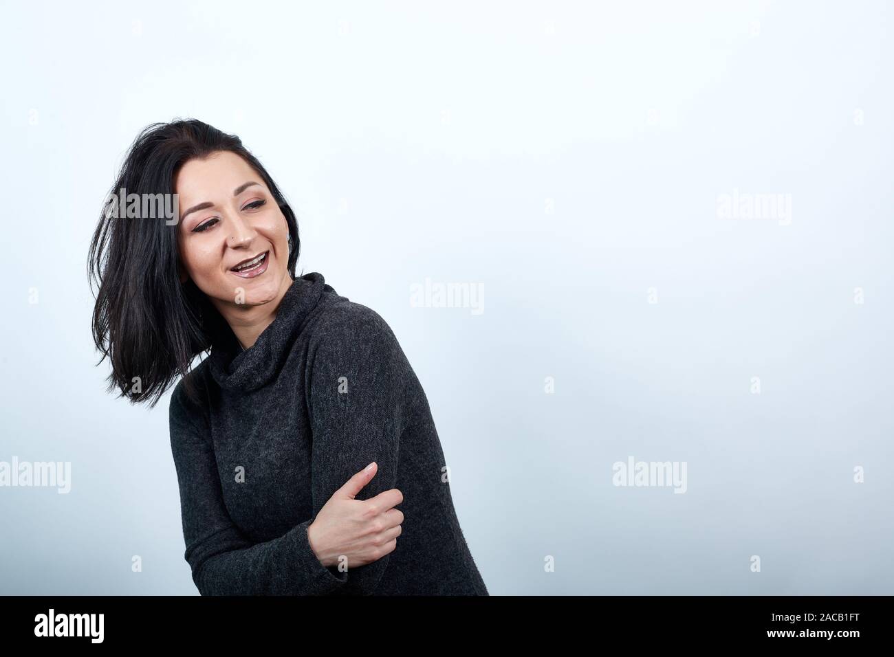 Beautiful woman crossed hands on chest, hugging herself, looking aside ...