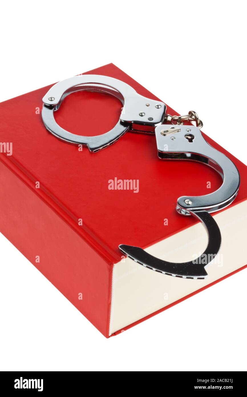 Handcuffs and law book Stock Photo - Alamy