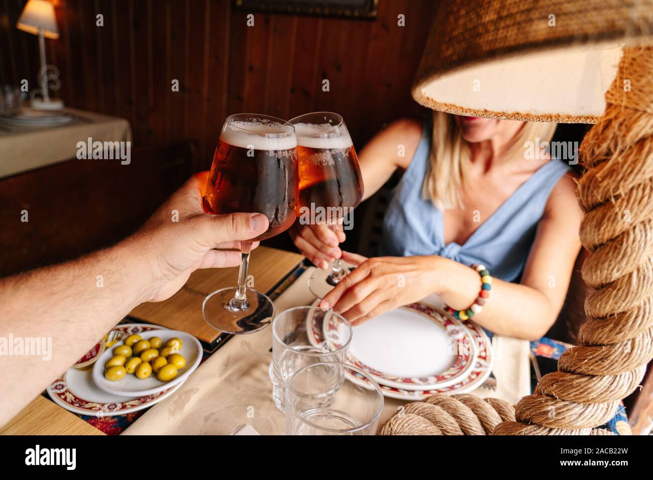 A beautiful caucasian blond woman toasting with beer restaurant next to ...