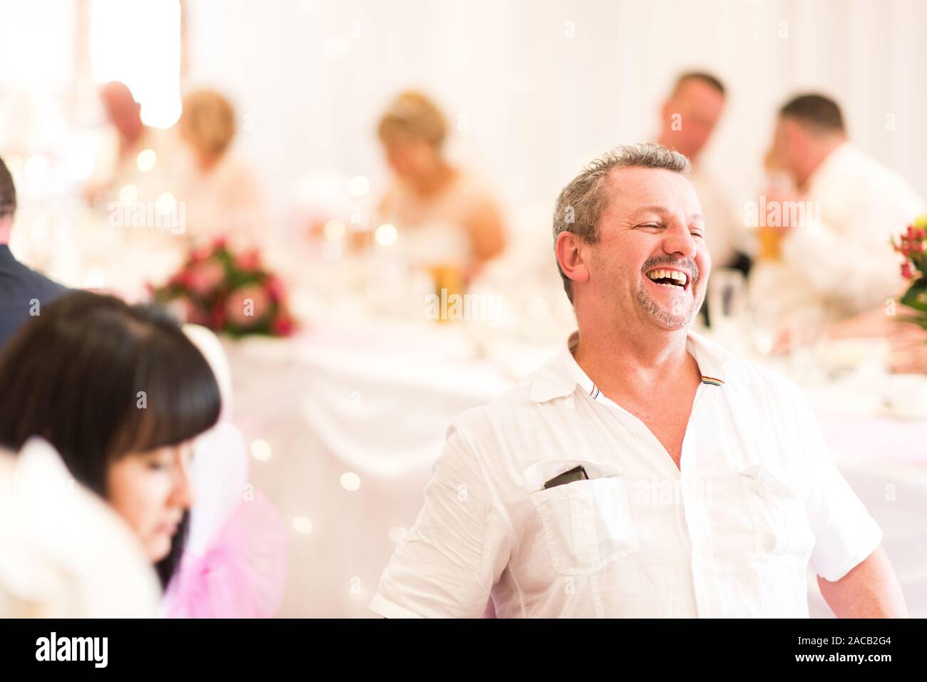 Wedding guests smiling, laughing and having fun at the wedding ...