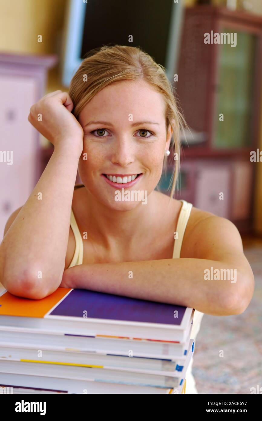 Student with a stack of books and computers Stock Photo - Alamy